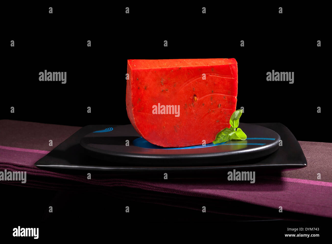 Red Gouda cheese still life isolated on black background. Luxurious ...