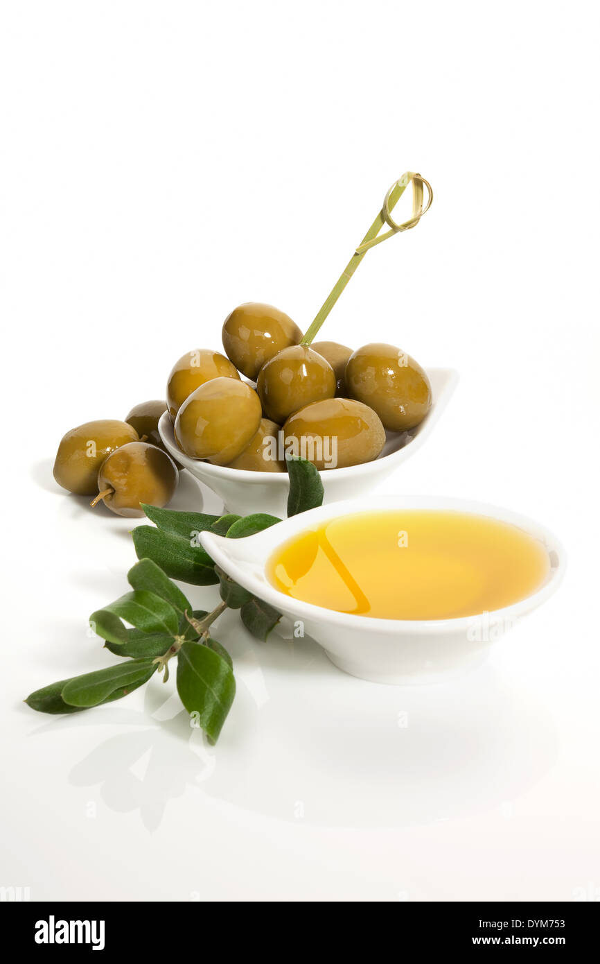 Green olives and extra virgin oliver oil with olive twig isolated on ...
