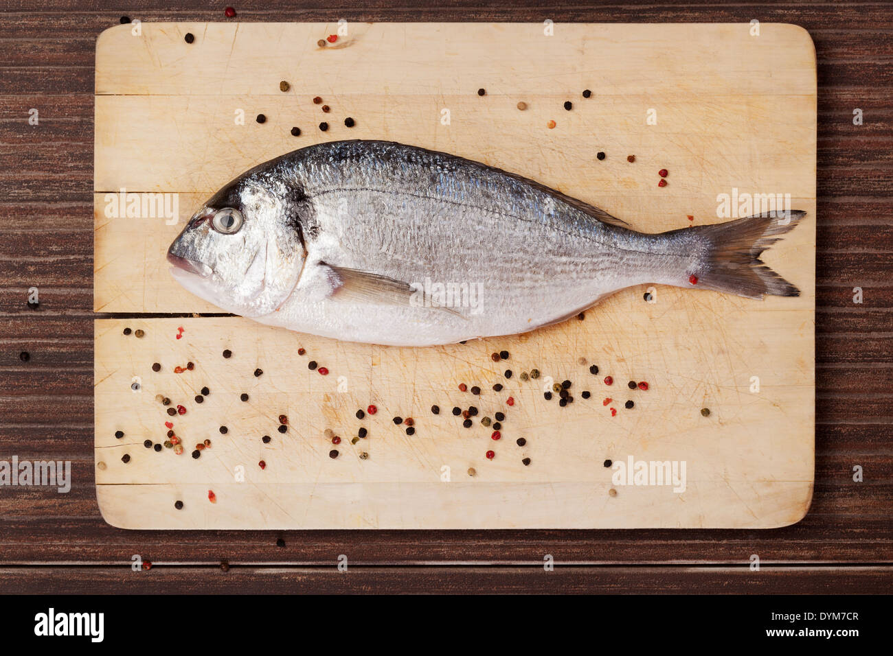 Delicious seafood concept in natural brown. Sea bream on wooden ...