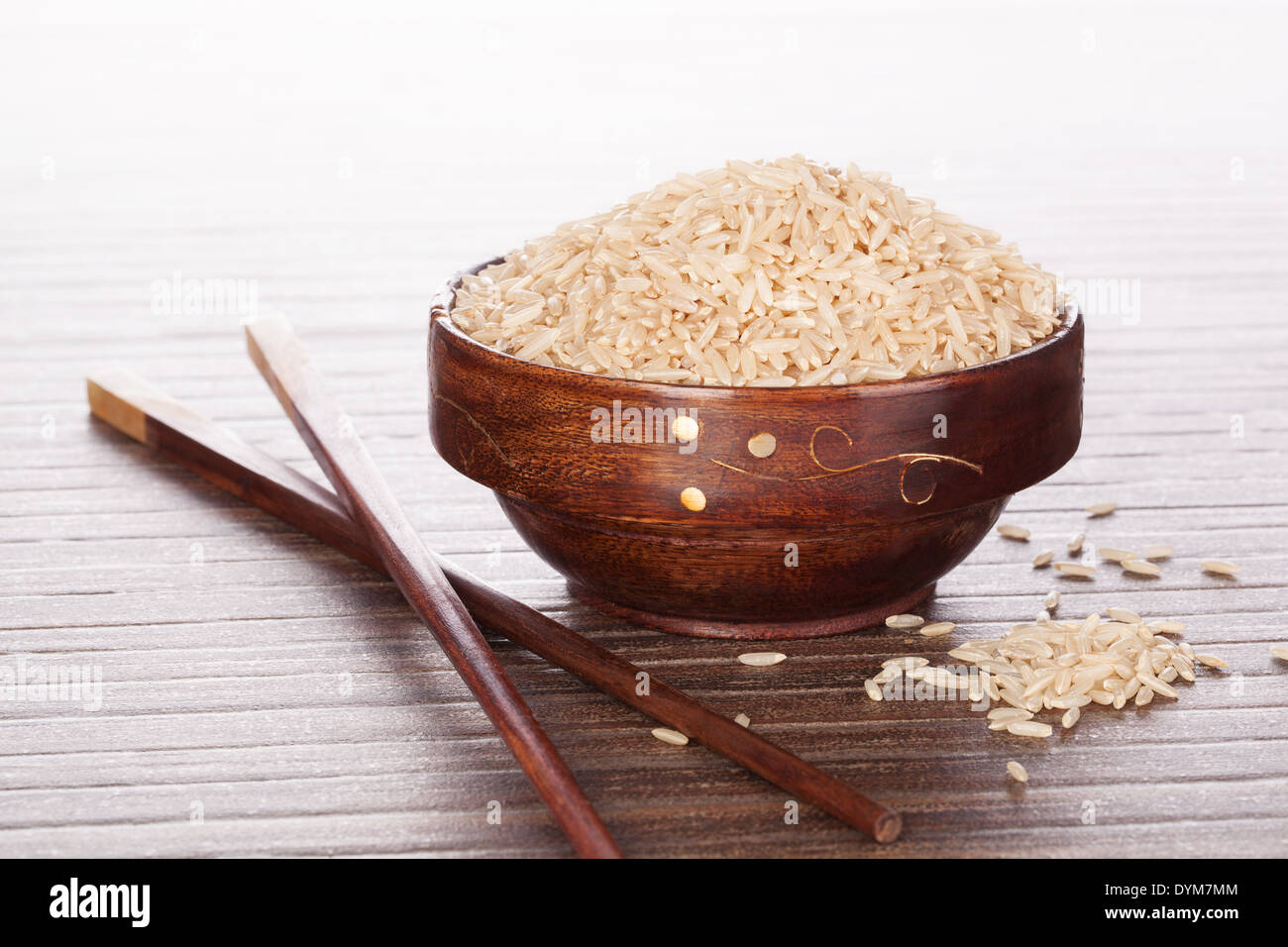 Luxurious rice background. Raw brown natural rice in round wooden asian ...