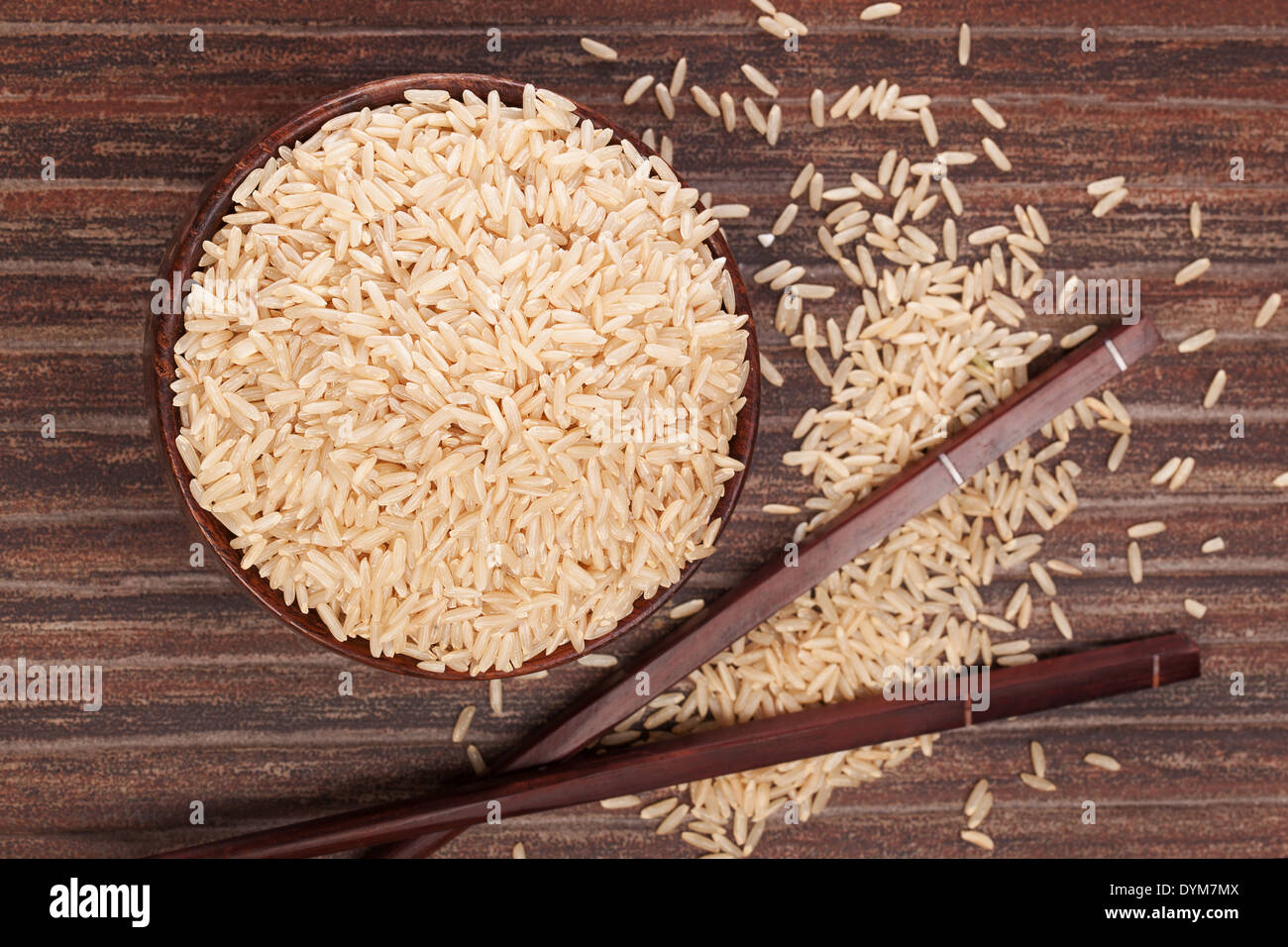 Natural rice background. Raw uncooked rice in wooden bowl with wooden ...