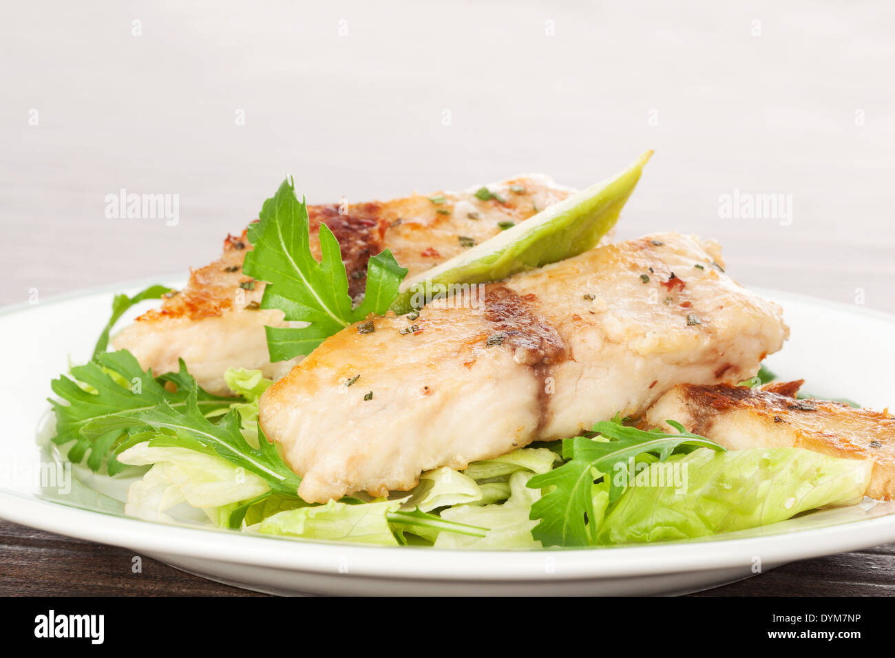 Grilled fish fillet with fresh salad, avocado and colorful spices on ...