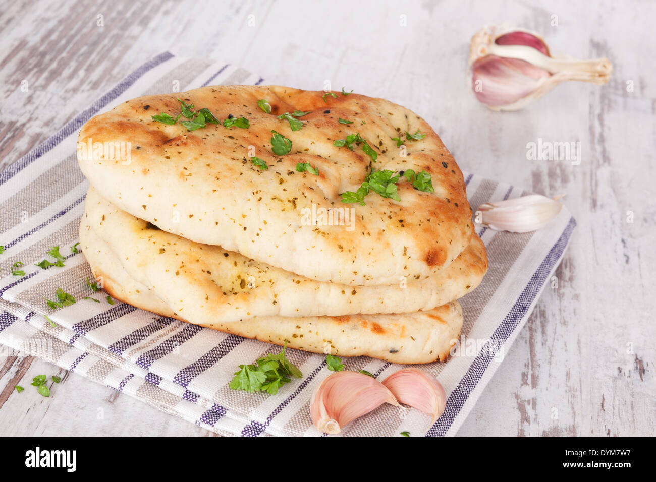 Luxurious naan flatbread stack on white wooden textured background ...