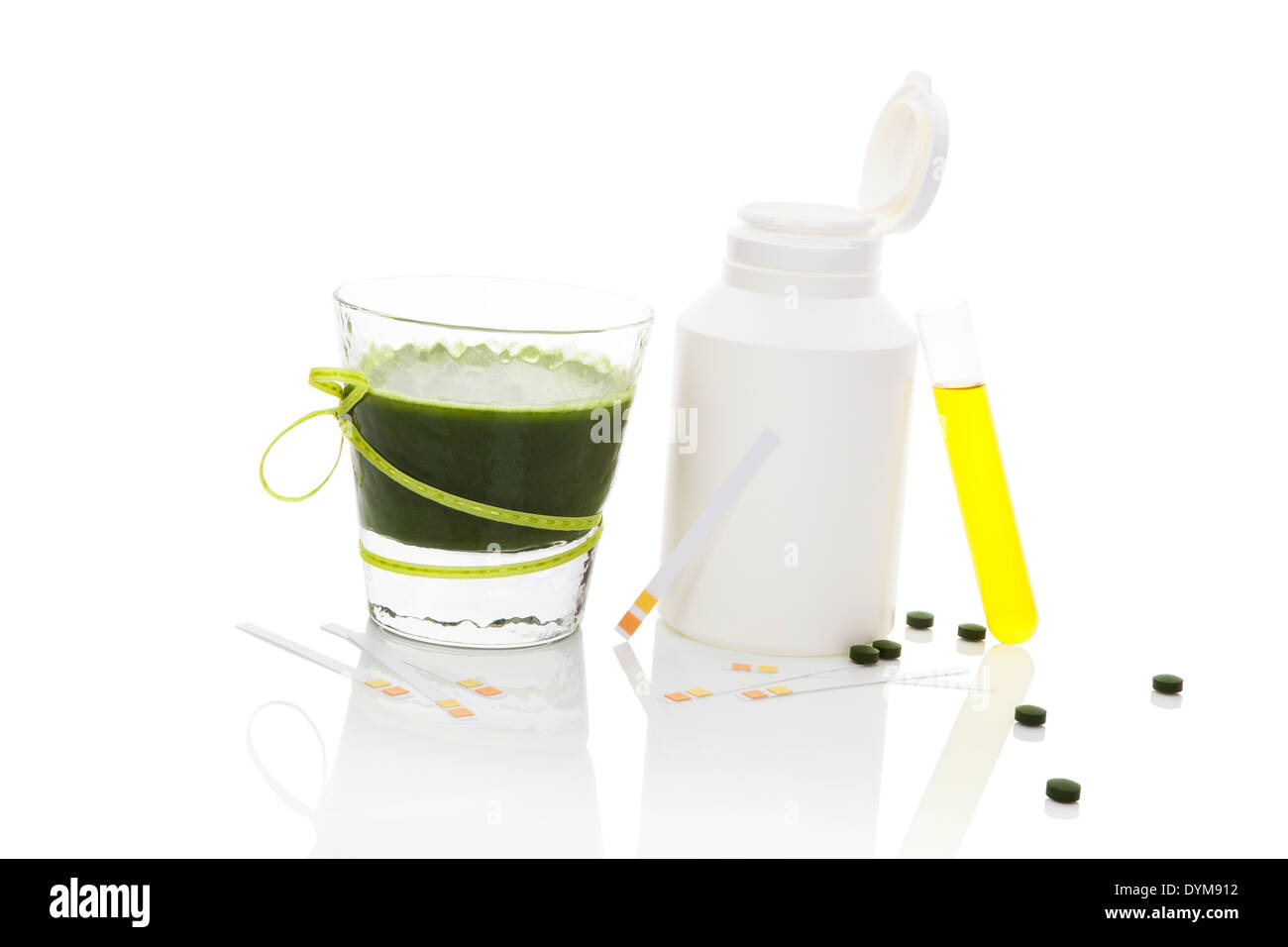 Detox still life. pH litmus test strips, green juice, white pill ...