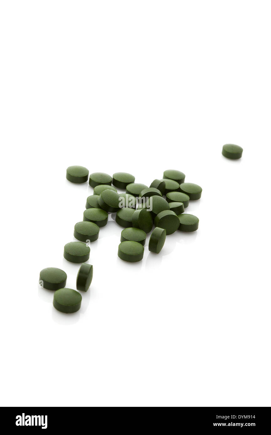 Chlorella pills pile isolated on white background. Green dietary ...