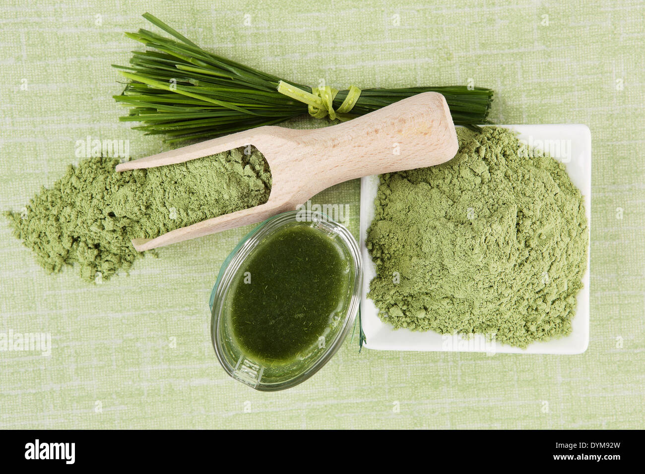 Green superfood background. Wheatgrass ground, barley grass blades and ...