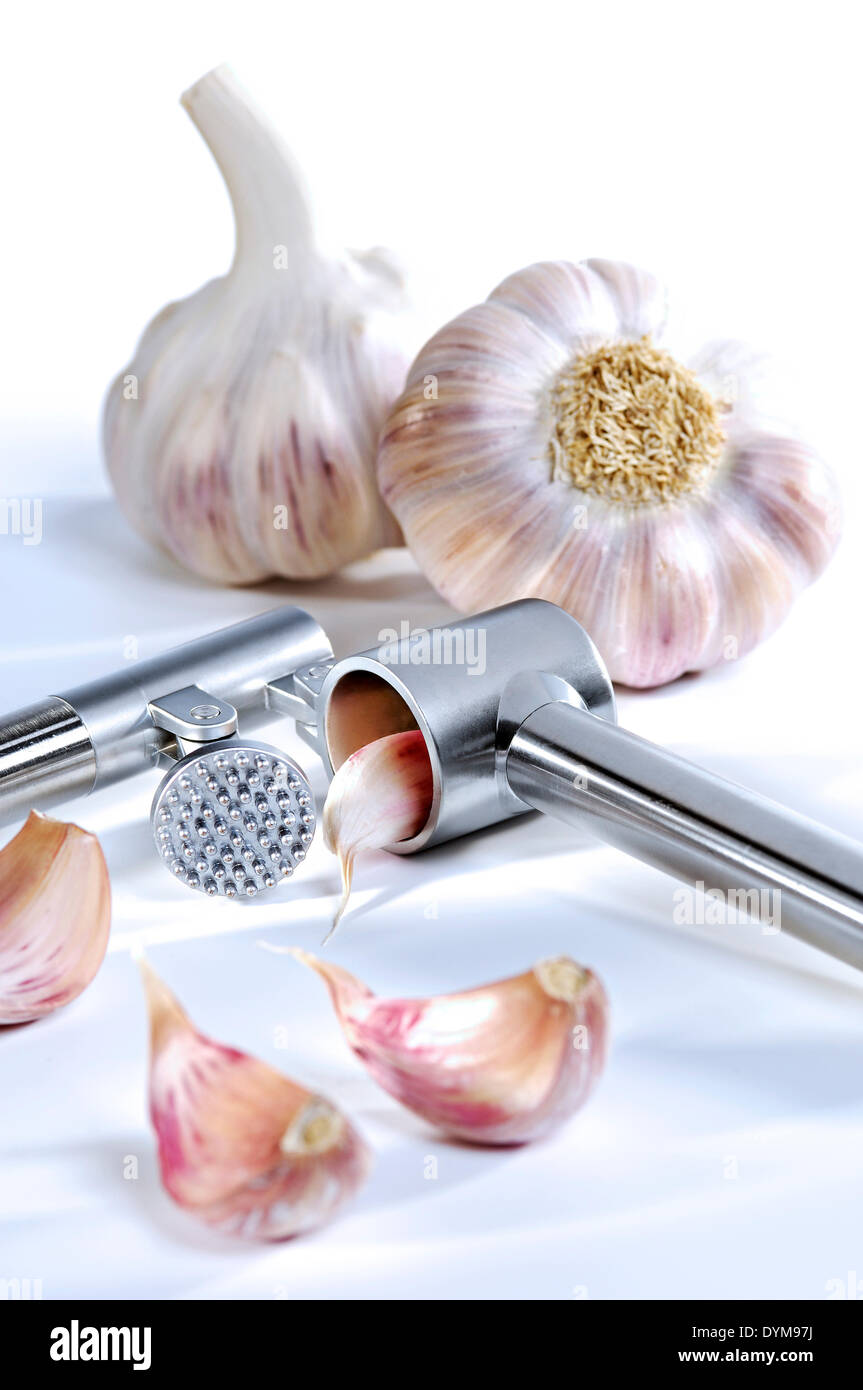 Garlic with a garlic press Stock Photo - Alamy