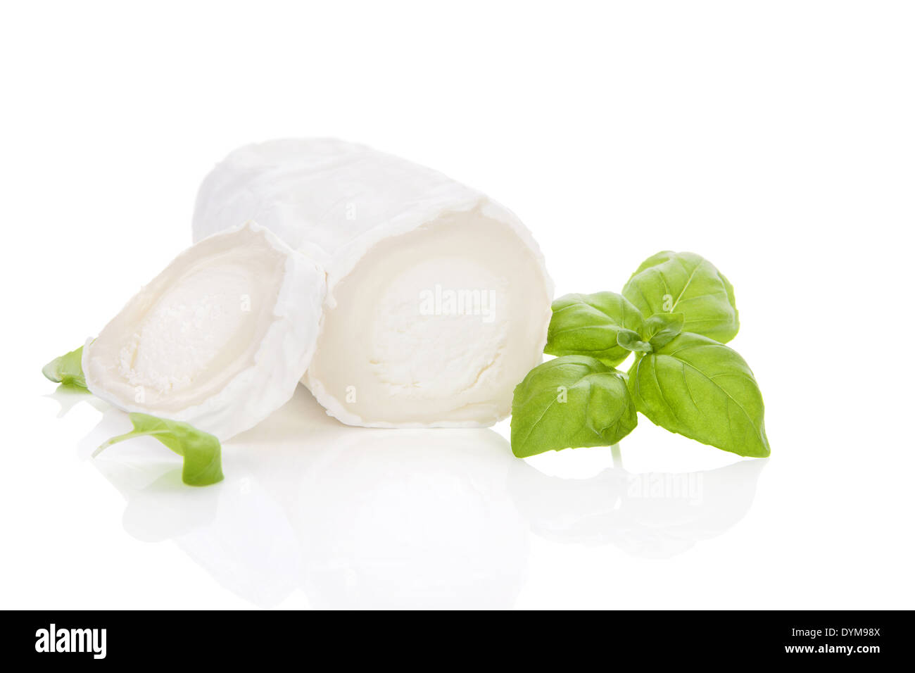 Delicious goat cheese slices and piece with fresh basil leaves isolated ...