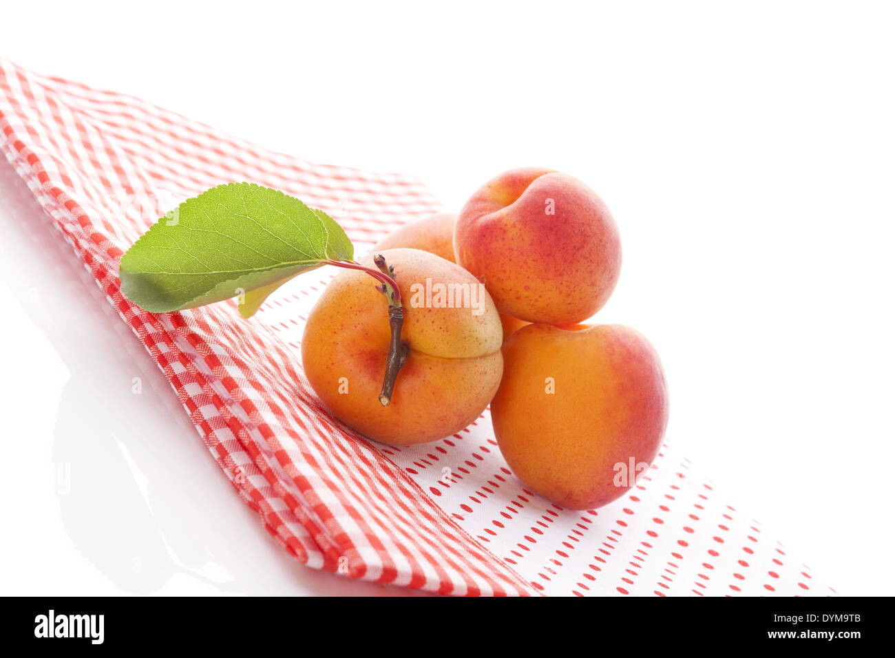Delicious ripe apricots on white and red napkin isolated on white ...