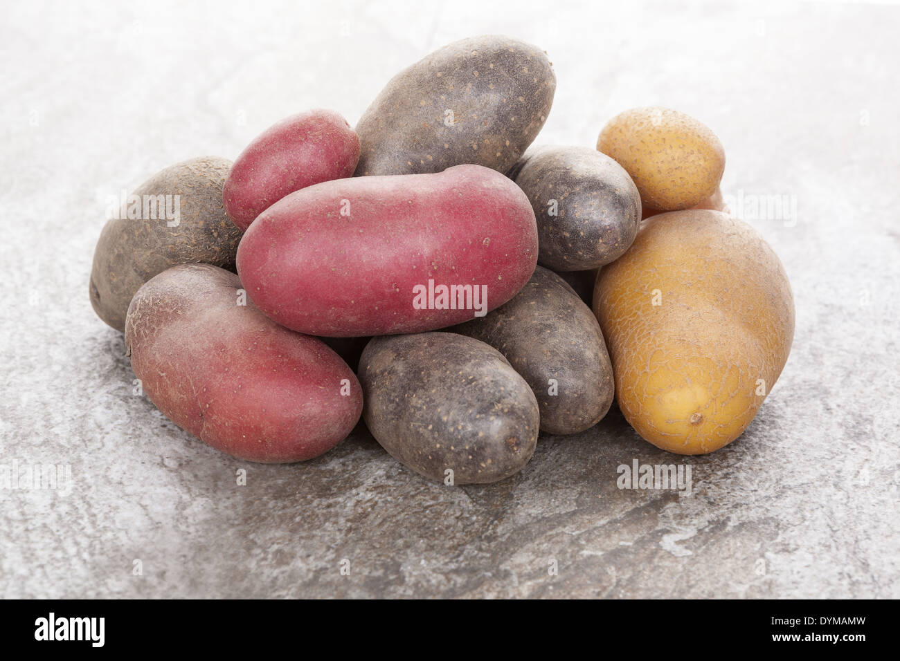 Various raw potatoes on natural stone background. Culinary vegetable ...