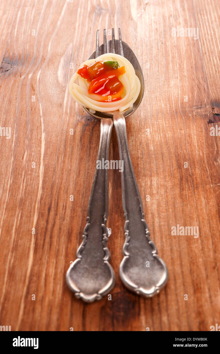 Traditional pasta eating. Pasta with red sauce on silver spoon with ...