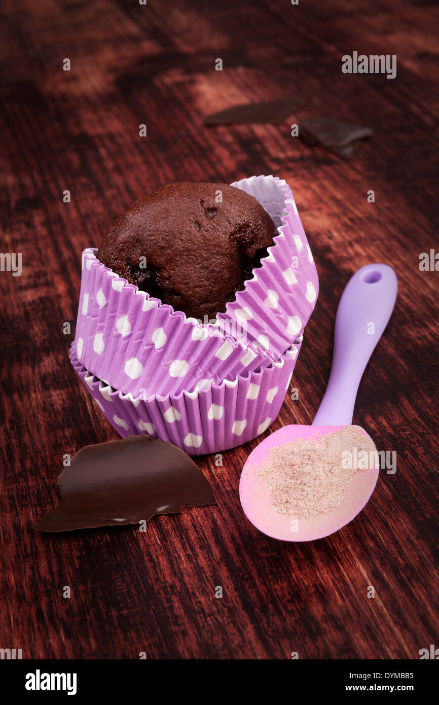 Chocolate cupcake in purple dotted paper baking form, chocolate bar and ...