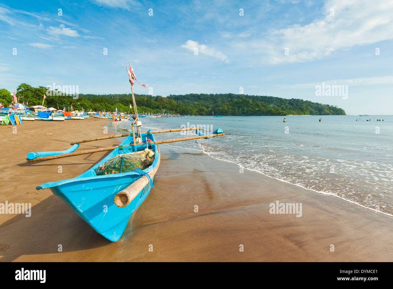 Outrigger fishing boat on the town beach, with the national park on the ...