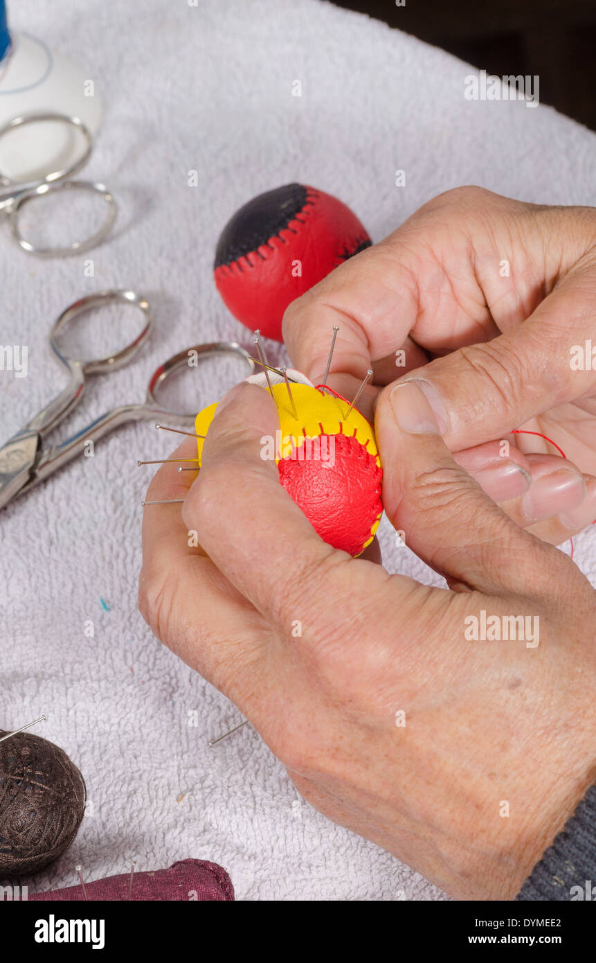 Expert hands sewing traditional sport balls Stock Photo - Alamy