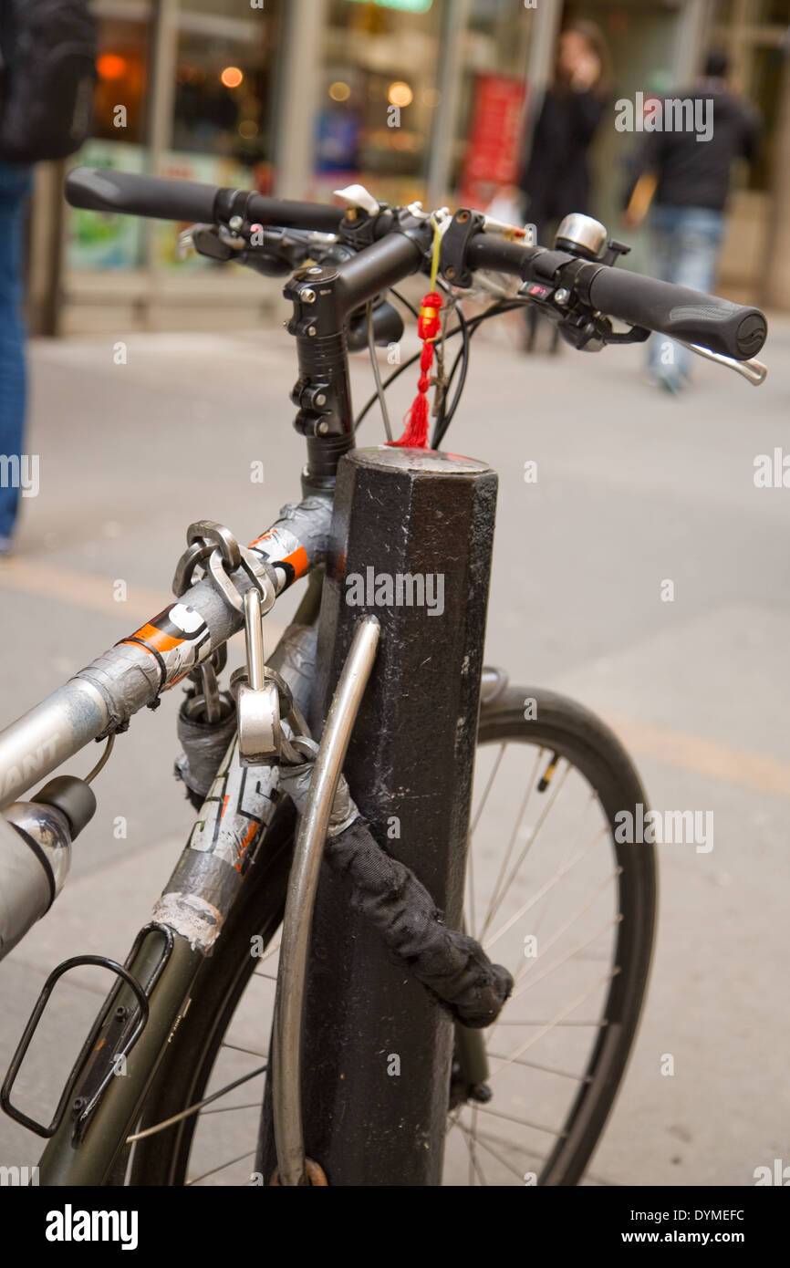bicycle locked on a sidewalk bicycle stand in New York City Stock Photo ...