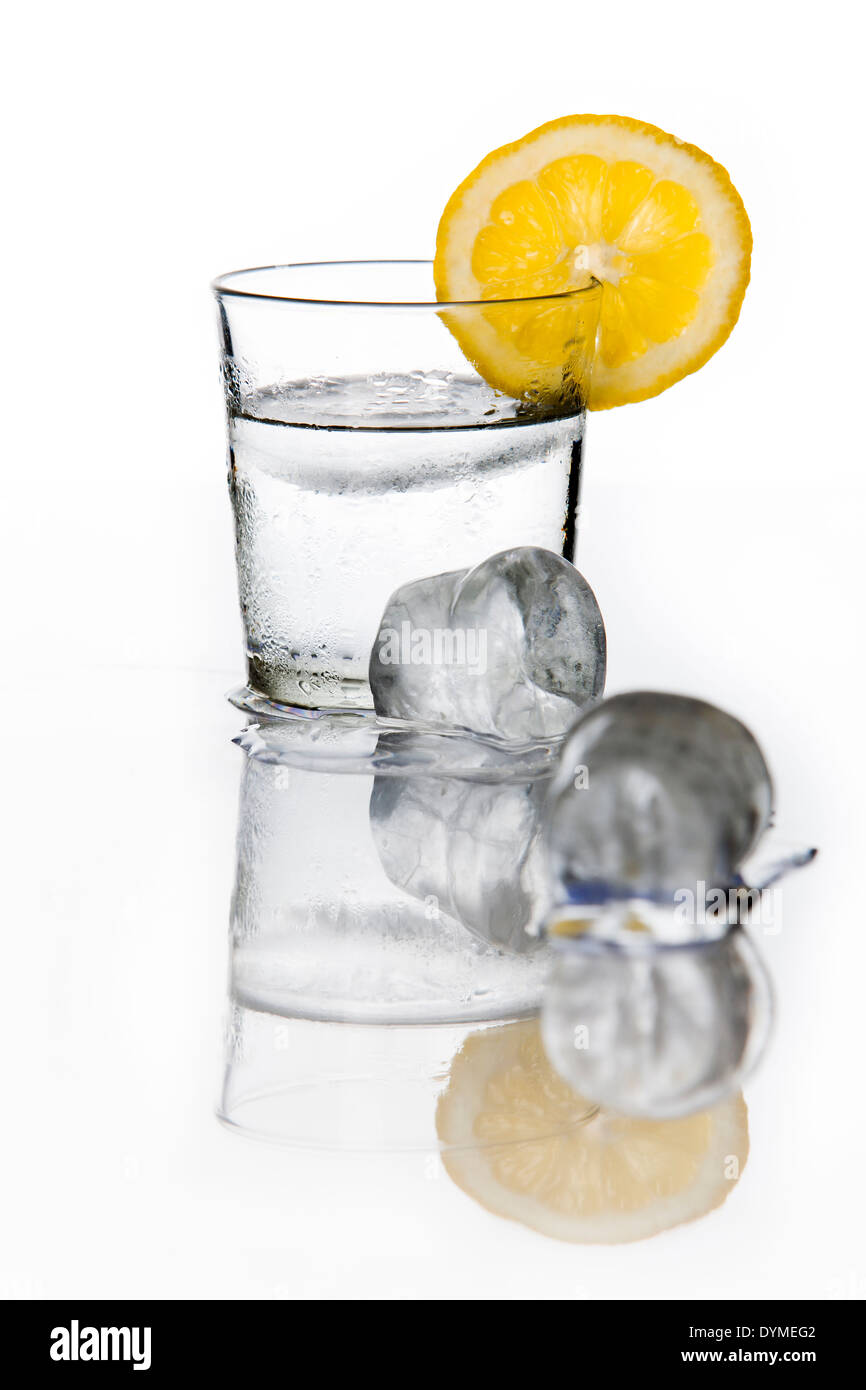 Glass of water with a lemon slice an ice cubes Stock Photo - Alamy