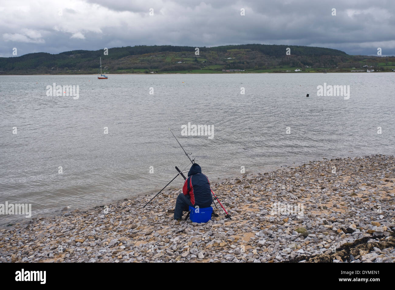 Man sea fishing at Red Wharf Bay on Anglesey North Wales UK Stock Photo ...