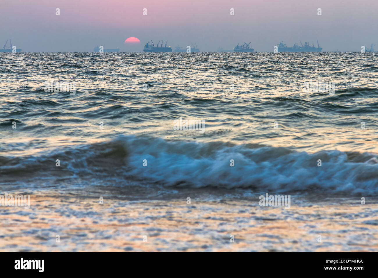 Scenic view of beautiful sunset above the Arabian sea. Cargo ship on ...