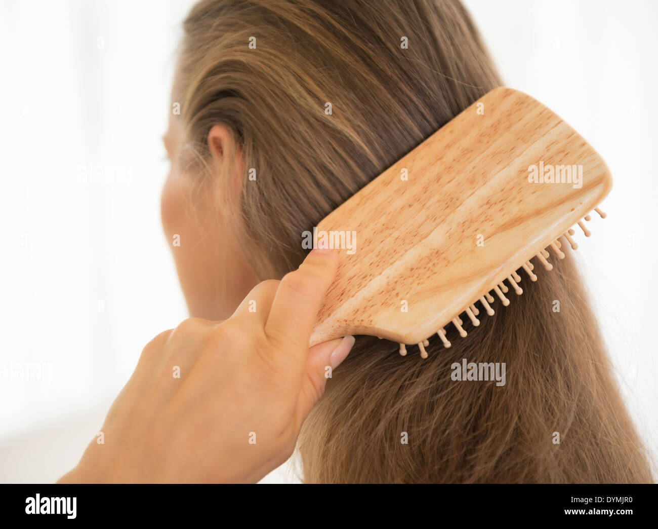 Closeup on young woman combing hair Stock Photo - Alamy