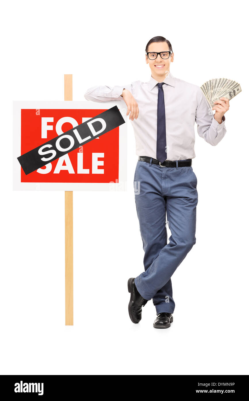Male realtor holding money next to a sold sign Stock Photo - Alamy