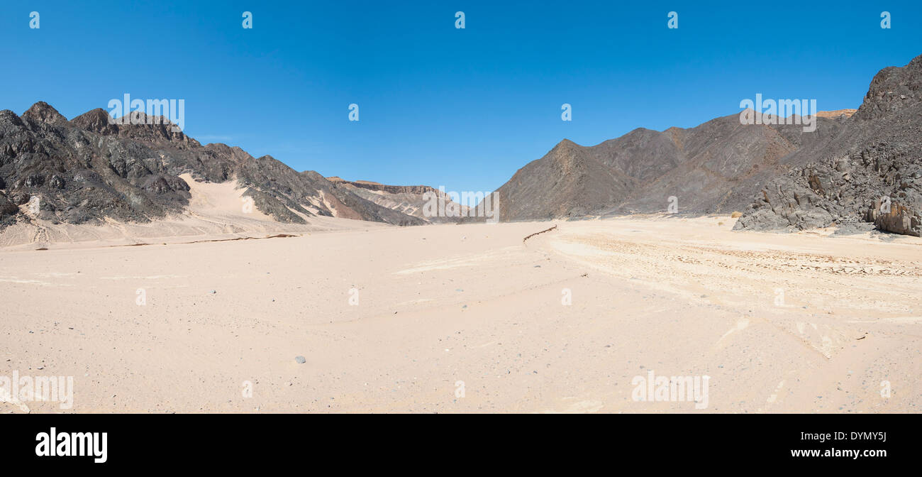 View down a dry wadi desert river valley in barren arid climate with ...