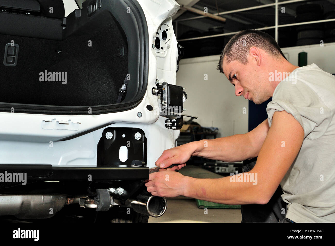 Mechanic assembling trailer hitch Stock Photo - Alamy