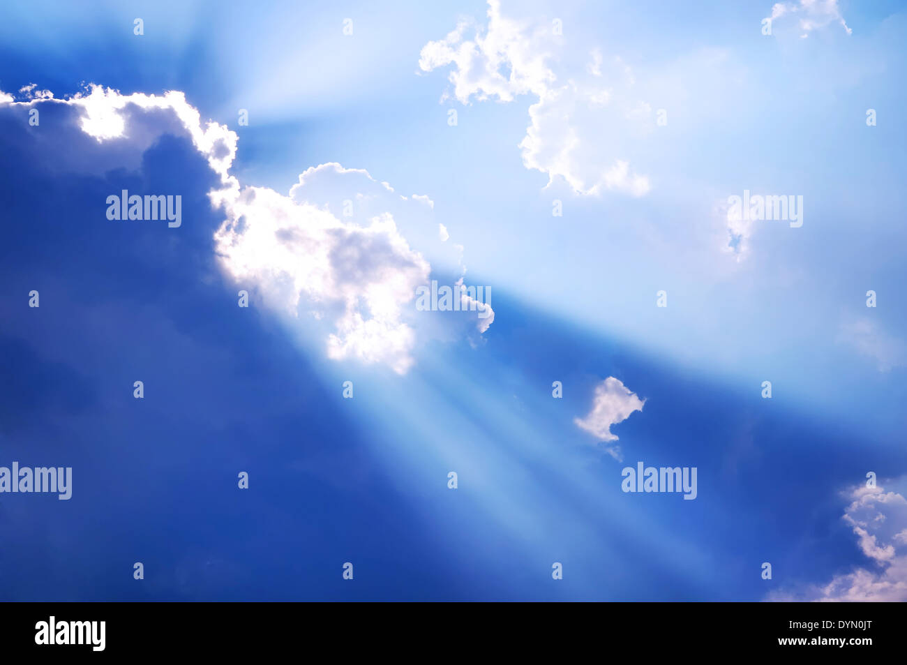 The Sun rays going through dark clouds Stock Photo - Alamy
