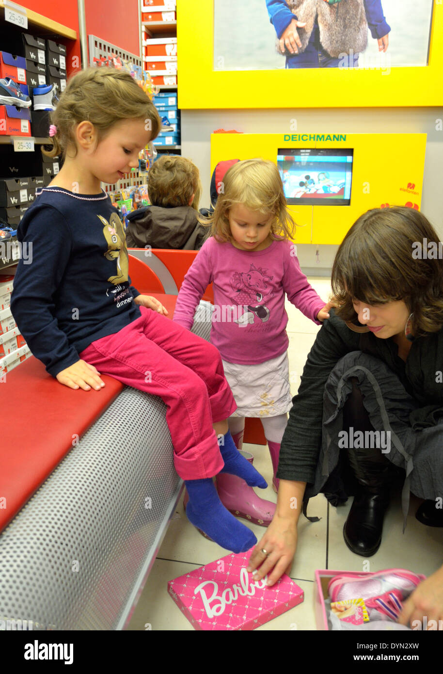In the shoe store, girl try shoes with Mother and sister Stock Photo ...