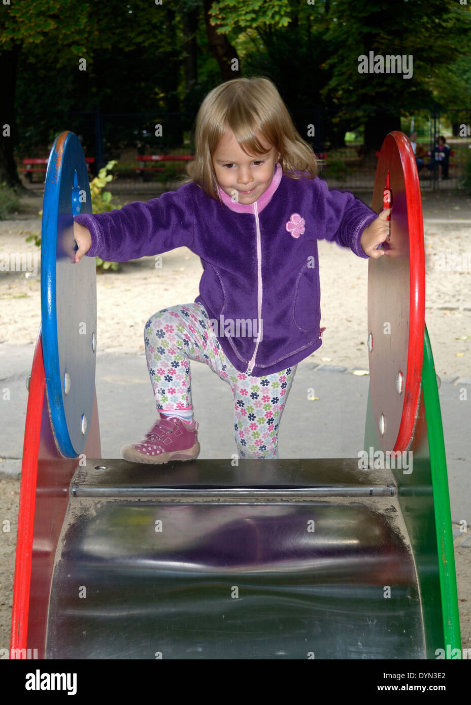 Cheerful little girl on top of the chute, playground in Budapest ...