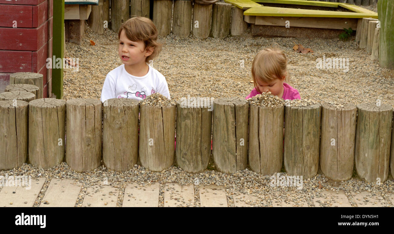 Two littl girls playing with pebbles Stock Photo - Alamy