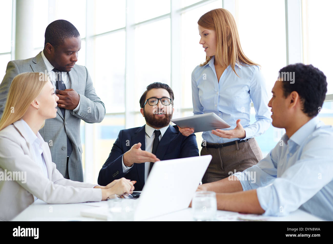 Group of business partners listening to their boss at meeting in office ...