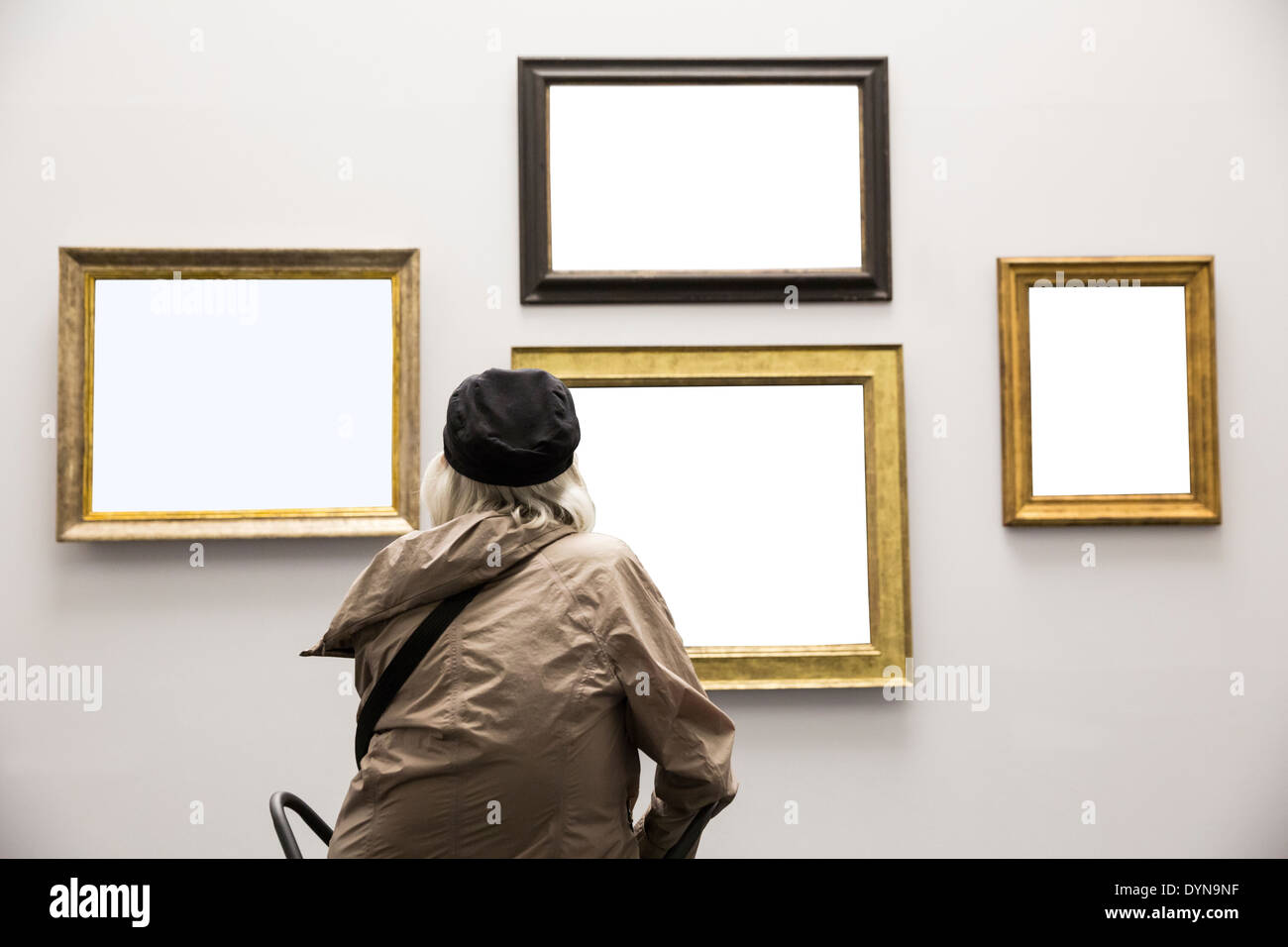 Old lady staring at blank paintings at an art gallery. Rear view Stock ...
