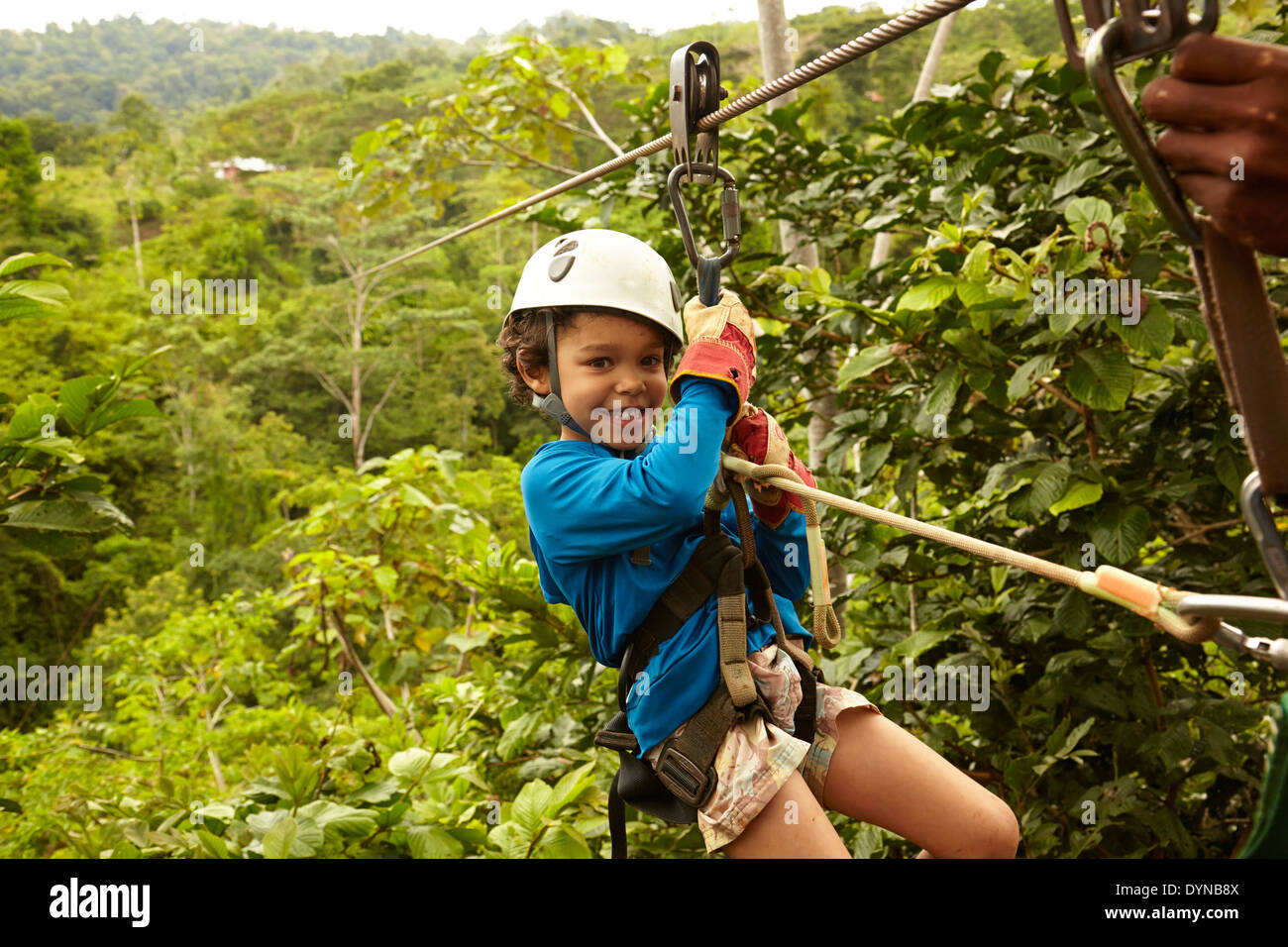 Mixed race boy zip lining Stock Photo - Alamy
