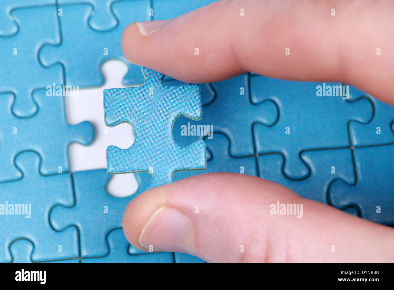 Fingers putting the last piece of puzzle in place Stock Photo - Alamy