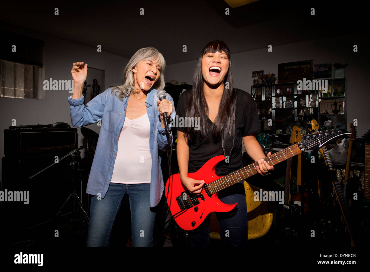 Mother and daughter playing music guitar in basement Stock Photo - Alamy