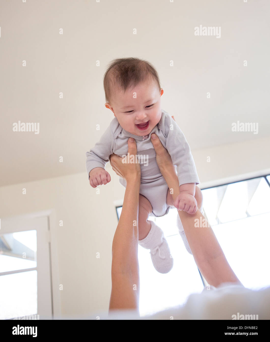 Mother holding baby girl overhead Stock Photo - Alamy
