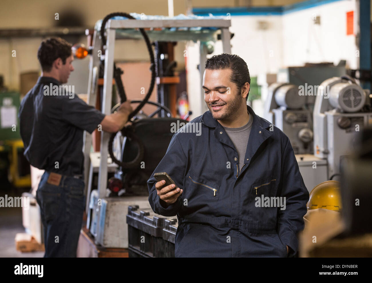 Worker using cell phone in warehouse Stock Photo - Alamy