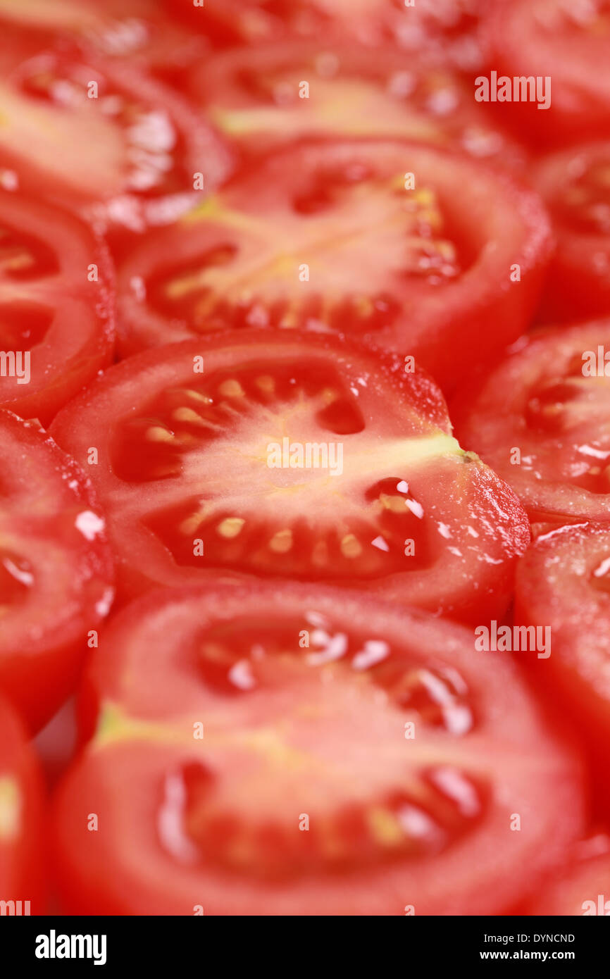 Collection of tomatoes cut in slices and forming a background Stock ...