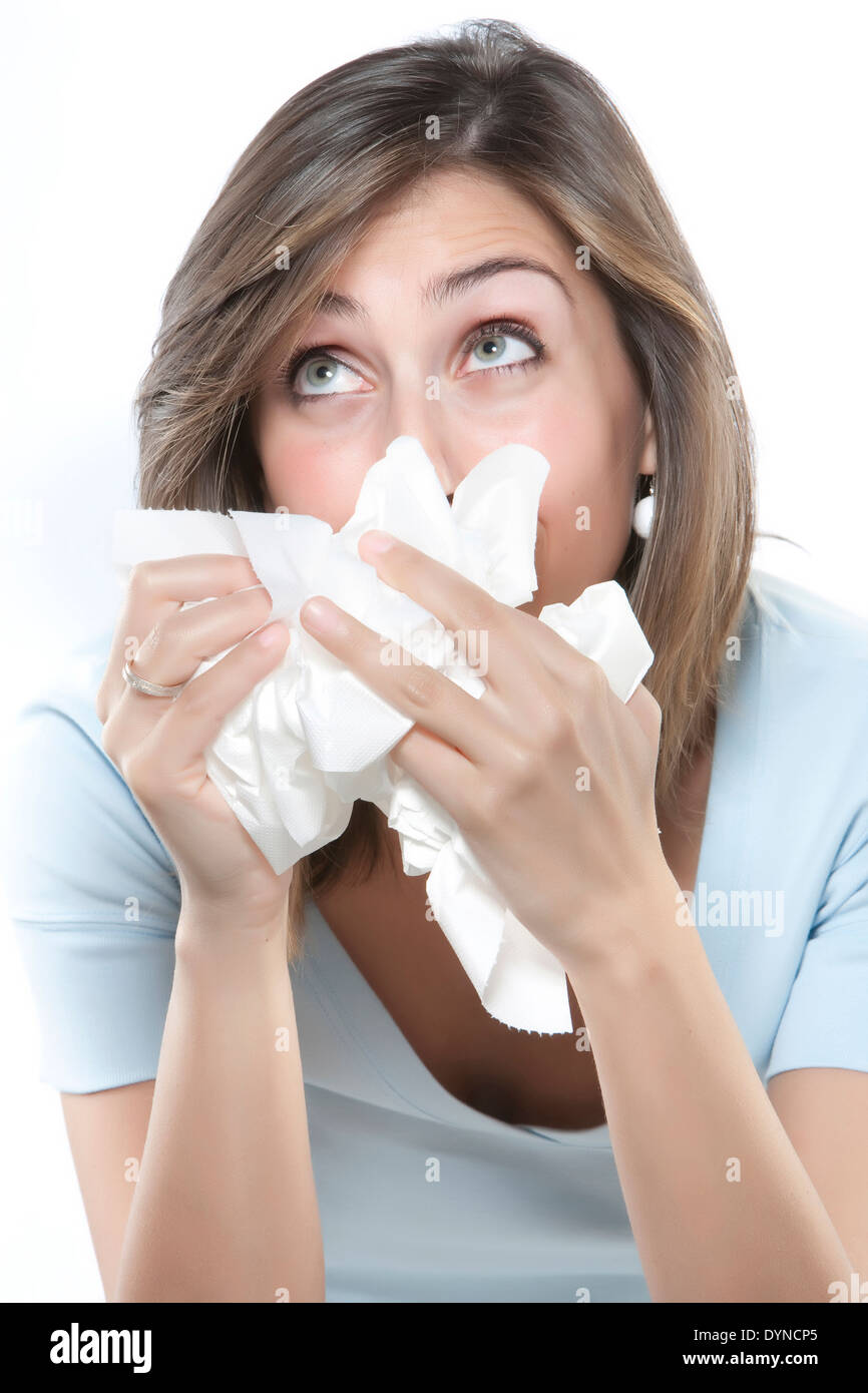 Woman blowing her nose into tissues Stock Photo - Alamy