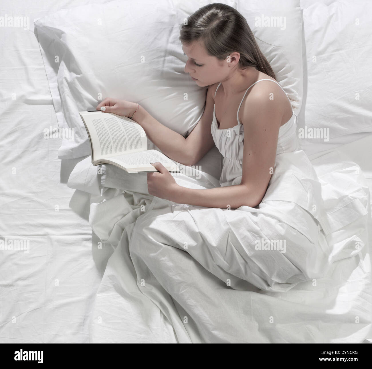 Hispanic woman reading in bed Stock Photo - Alamy