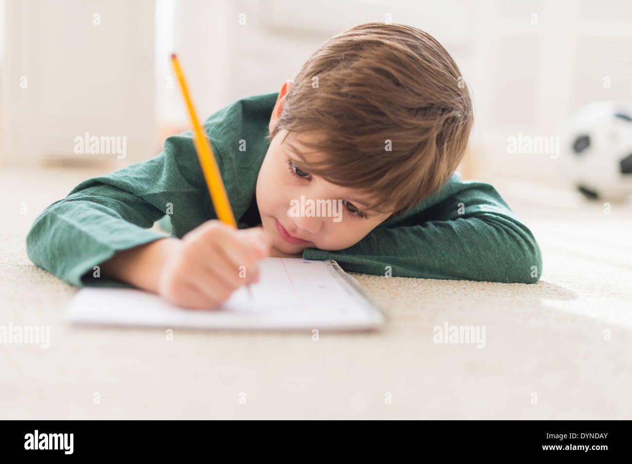 Hispanic boy doing homework on floor Stock Photo - Alamy