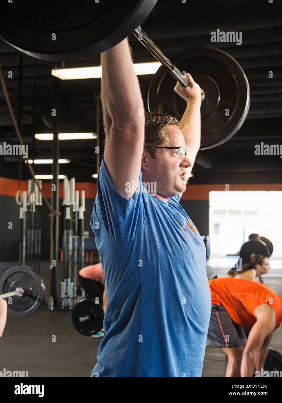 Man lifting weights in gym Stock Photo - Alamy