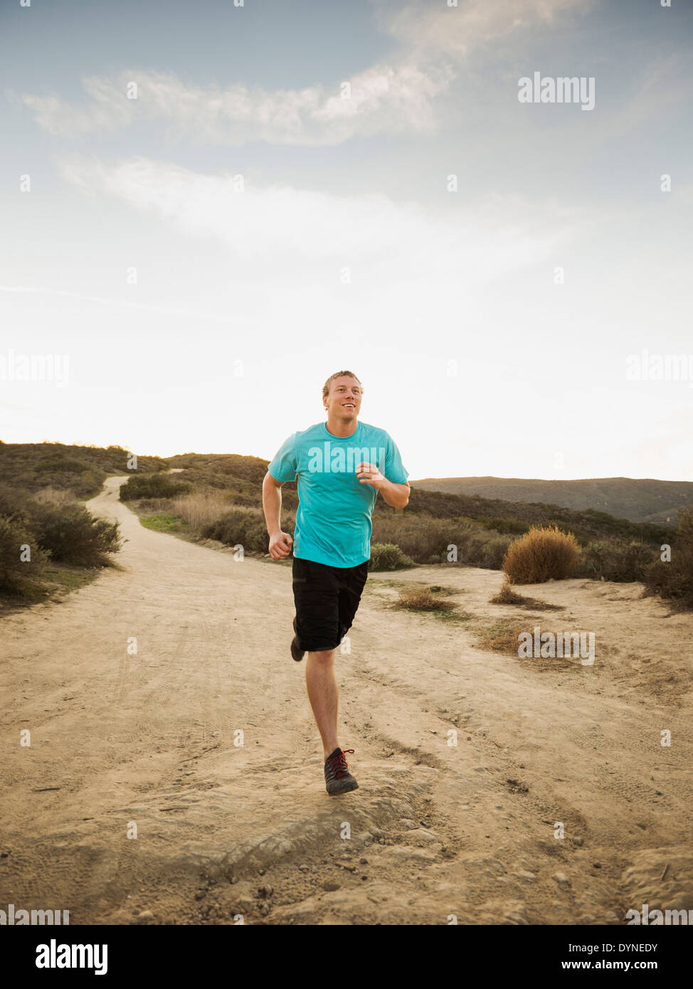 Caucasian man jogging on dirt path Stock Photo - Alamy