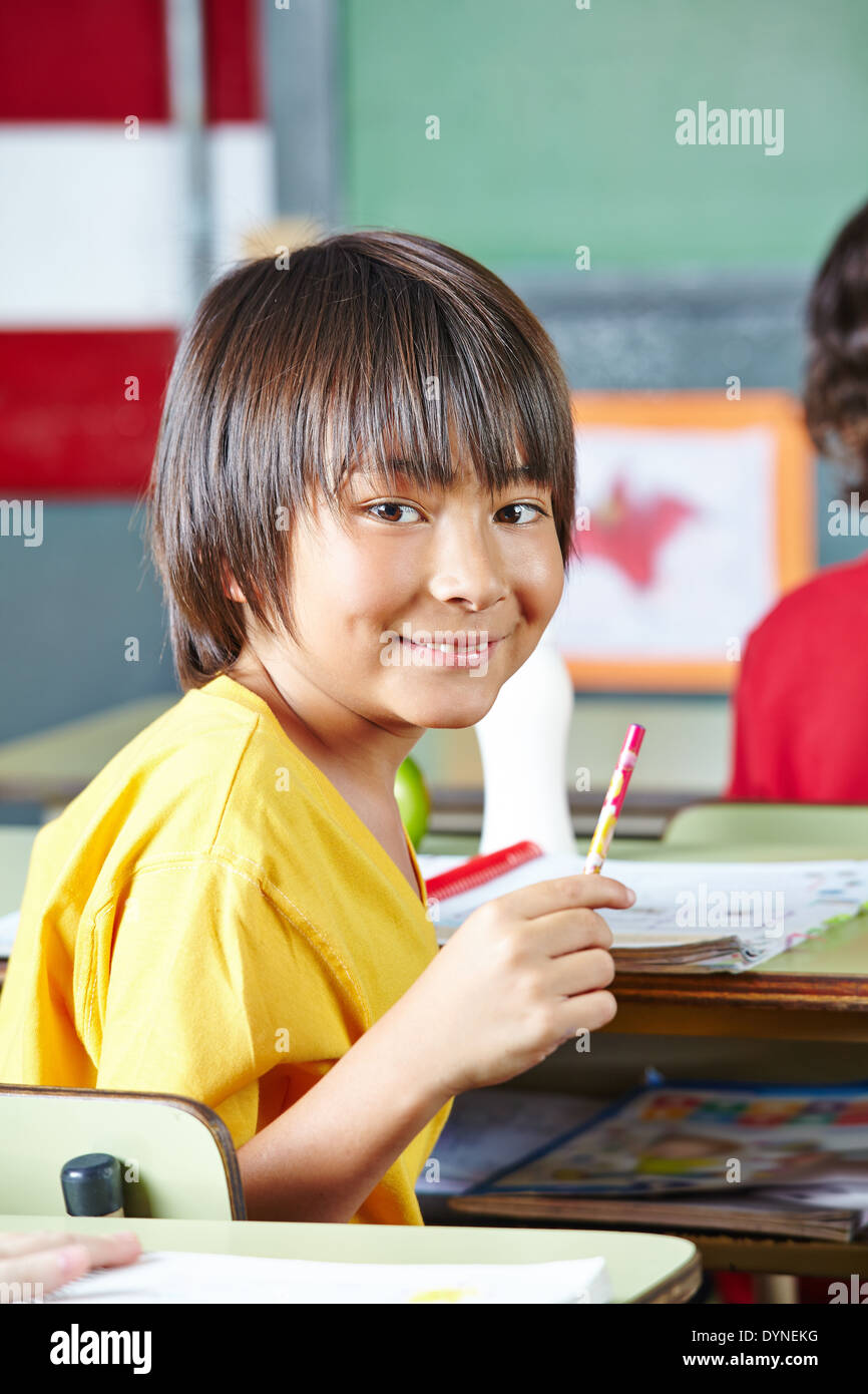 Japanese boy smiling in elementary school class at his desk Stock Photo ...