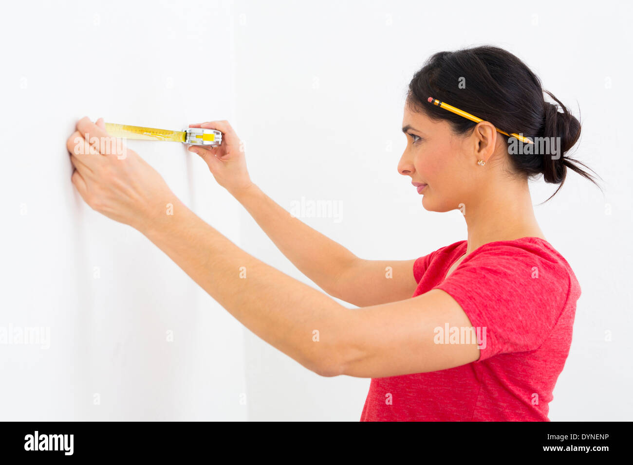 Mixed race woman using measuring tape Stock Photo - Alamy