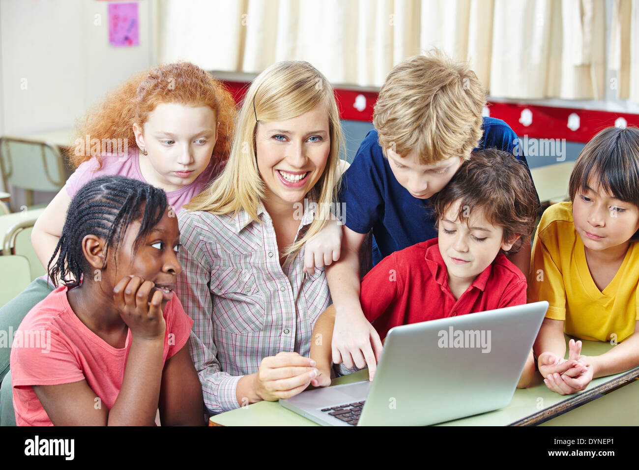 Children with teacher in computer science class in an elementary school ...