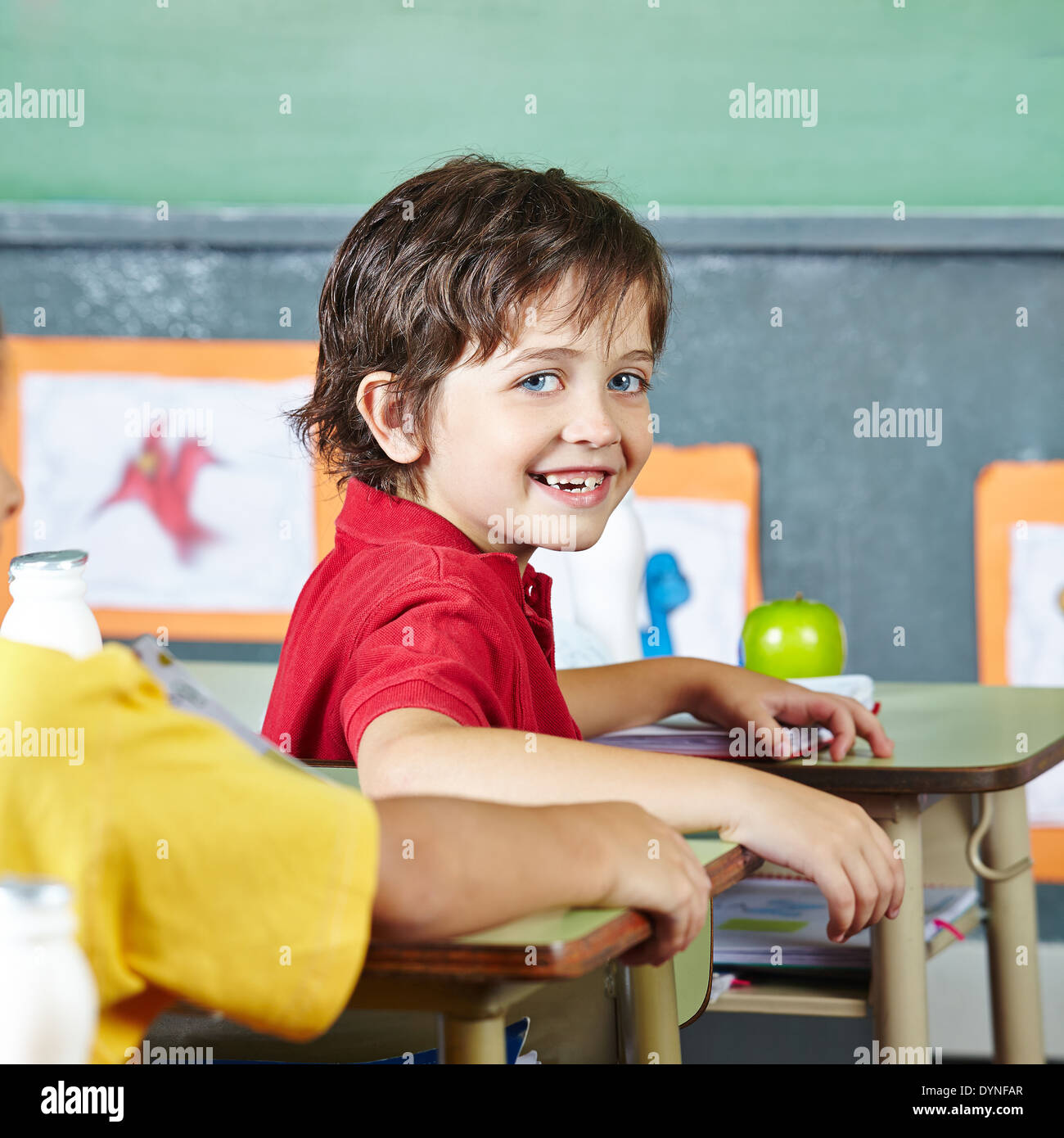 Happy abecedarian child sitting smiling in elementary school classroom ...