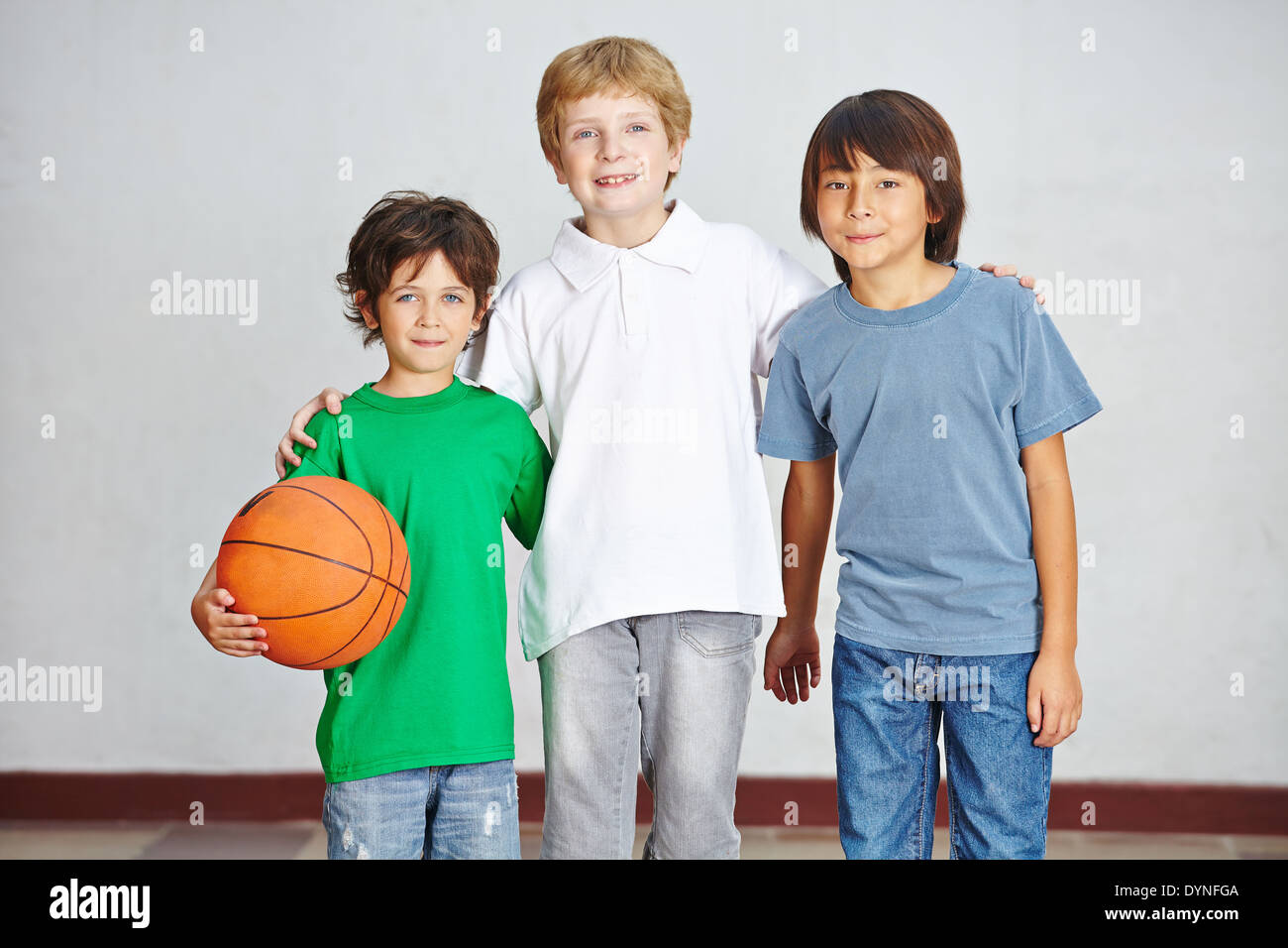 Three happy children with a basketball in an elementary school Stock ...