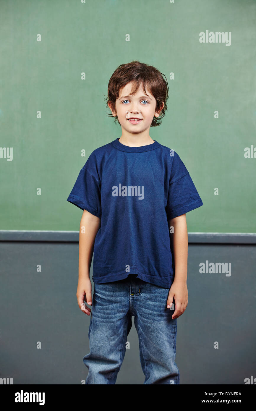 Happy boy in elementary school in front of empty chalkboard Stock Photo ...