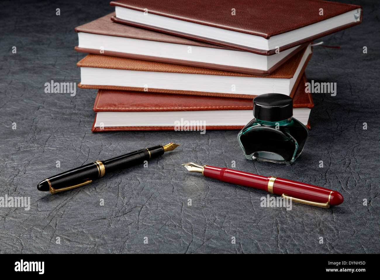 fountain pens with ink and a pile of organizers Stock Photo - Alamy